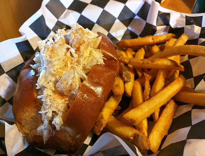 Pure Maine magic: sweet crab meat piled high on a buttery roll, with golden fries standing guard like delicious sentinels.