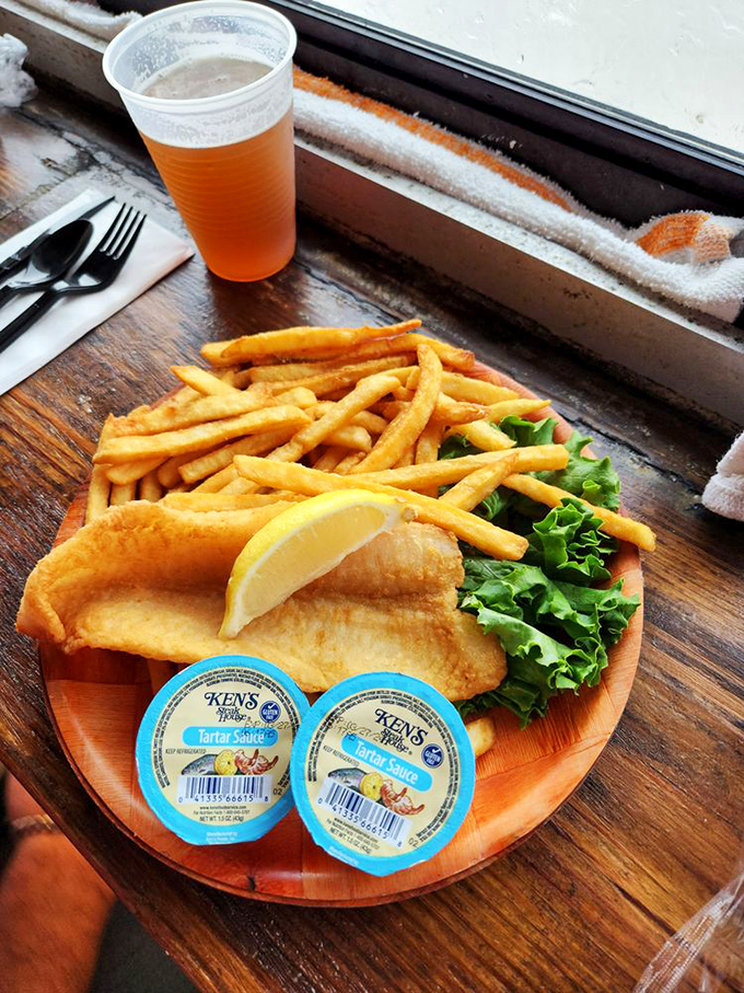 Golden-battered fish resting on a bed of perfectly crisp fries – simple perfection that needs nothing more than a squeeze of lemon.