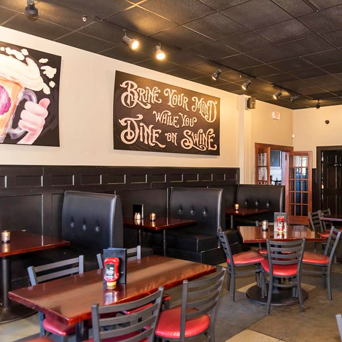 "Bring Your Mind While You Dine on Swine" - clever wordplay meets comfortable booth seating in this cozy dining space.