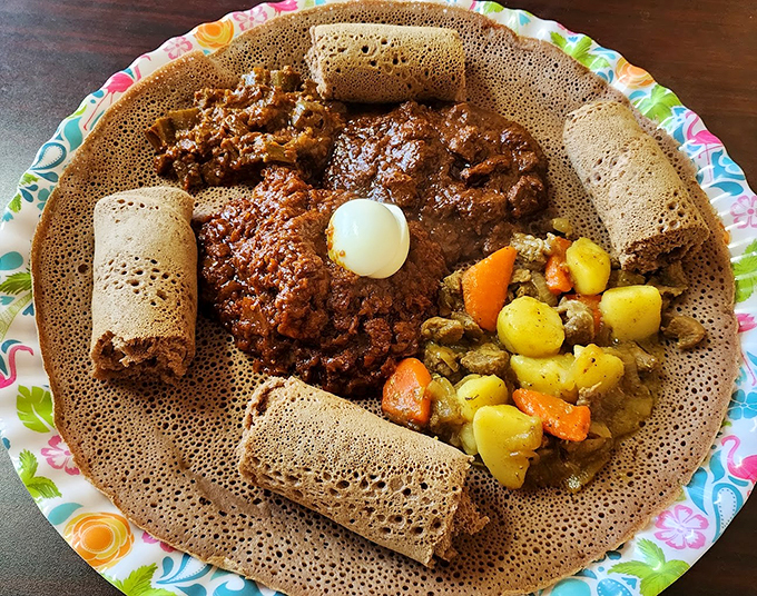 A canvas of injera cradles vibrant stews and vegetables. It's like an edible plate that's part of the meal - genius!
