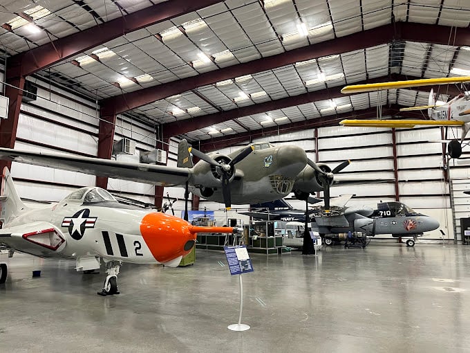 Classic warbirds share space with sleek modern aircraft, creating a timeline of aviation history under one impressive roof.