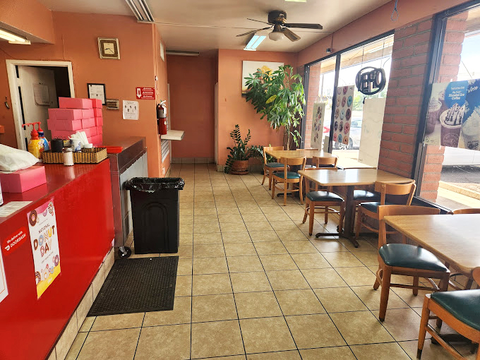 Simple wooden tables and coral-colored walls create a cozy spot where donut dreams come true.