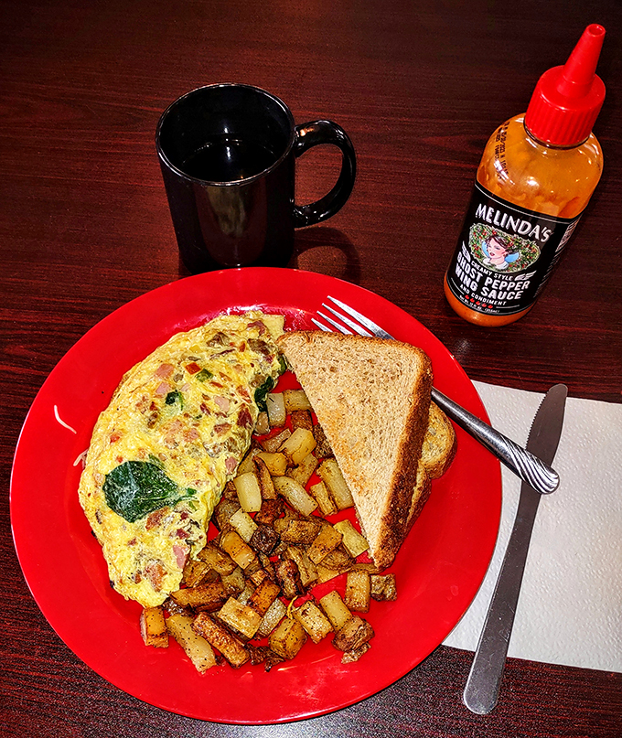 Behold, the omelet of champions! This golden masterpiece is packed with more fillings than your grandma's secret diary. Don't forget the hot sauce!