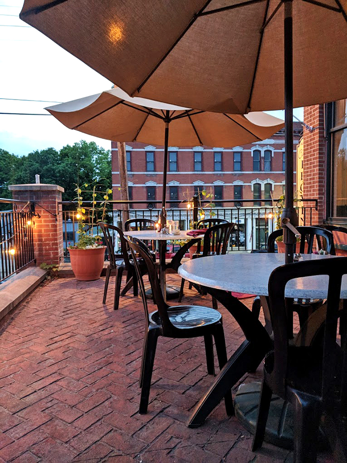 As evening falls, the outdoor terrace transforms into a romantic escape, complete with twinkling lights and historic brick buildings as your backdrop.