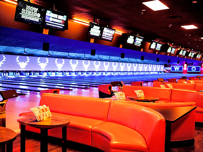 Curved booths in cherry red vinyl offer front-row seats to the bowling action, channeling classic American bowling alley charm.