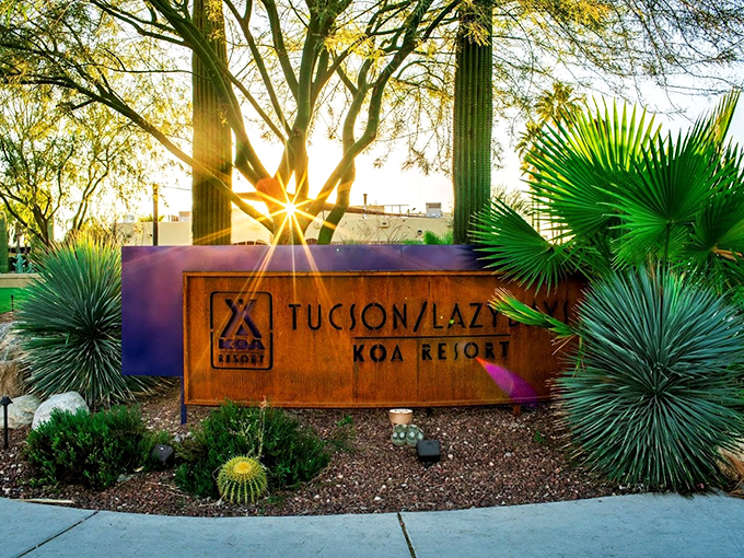 A sign you've arrived at camping nirvana. The sun's dramatic cameo behind this entrance marker sets the stage for your desert adventure. Photo credit: Tucson / Lazydays KOA Resort
