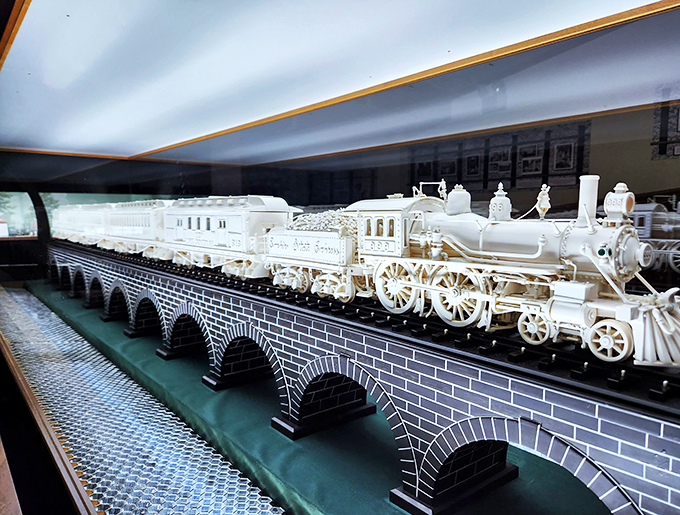 A white-knuckle ride in white wood. This pristine locomotive looks ready to chug right off its display and into history.