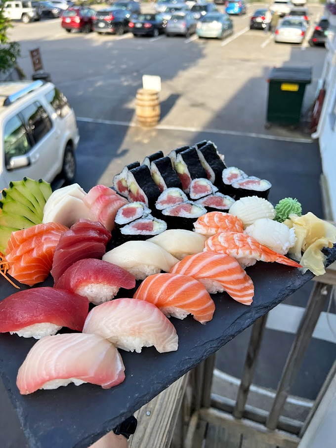 Fresh nigiri lined up like colorful jewels on slate &ndash; each piece a perfect bite of ocean-fresh happiness.