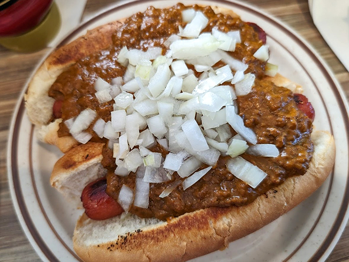 This isn't just any hot dog - it's a Michigan-style masterpiece, crowned with chili and diced onions that mean serious comfort food business.