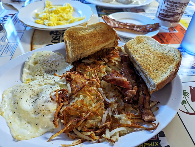 Golden hash browns, crispy yet tender, nestled next to eggs so perfect they could make a hen blush with pride.
