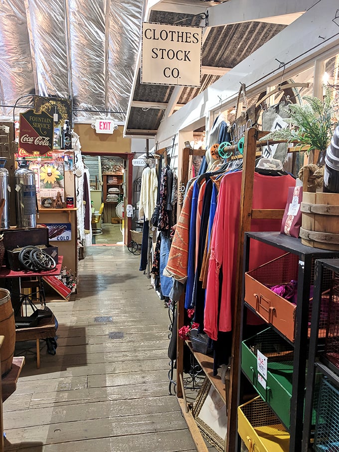 The "Clothes Stock Co." sign isn't lying - this aisle is packed tighter than a hipster's suitcase for Coachella. Vintage fashion galore!