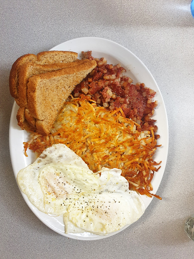 The holy trinity of breakfast: crispy hash browns, sunny-side-up eggs, and toast that could make a vegetarian weep.