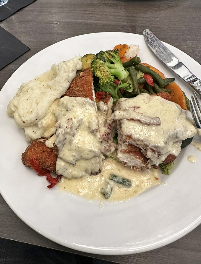 A symphony of textures: crispy breaded chicken, creamy sauce, and vibrant vegetables that make every bite worth savoring.