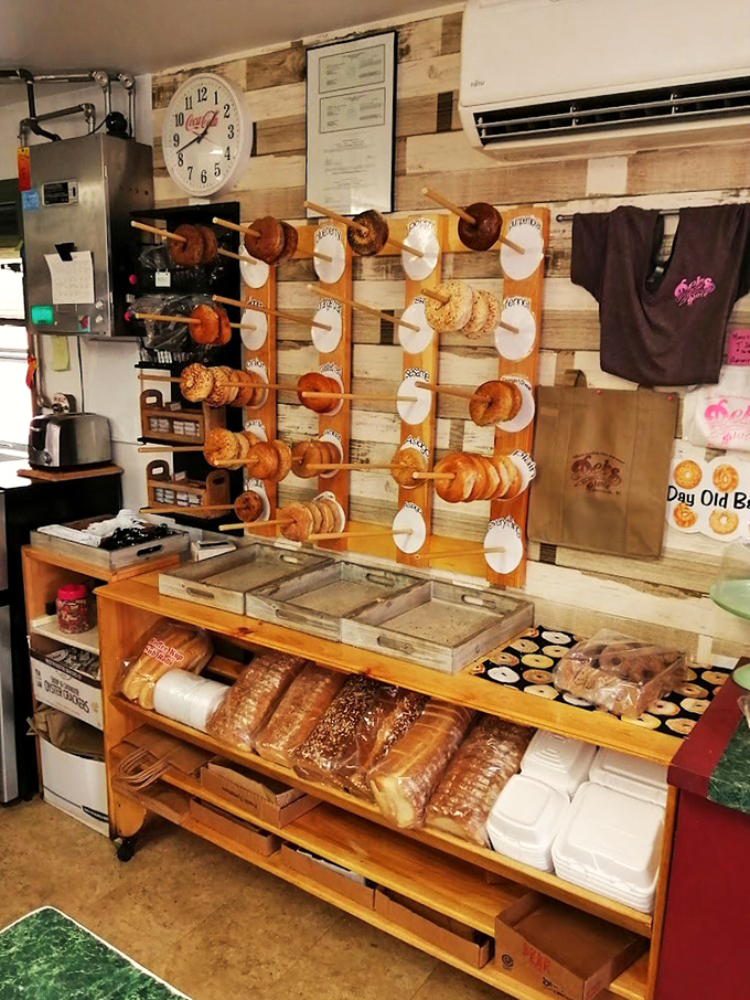 The bagel wall of fame - where every variety gets its moment to shine on wooden pegs, fresh and ready for action.