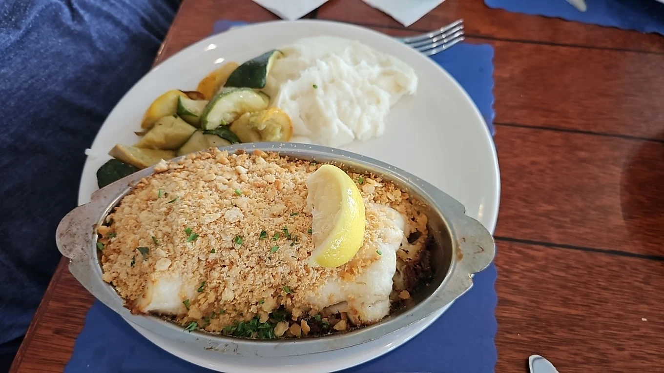 Golden-crusted haddock rests beneath a crown of buttery crumbs, proving that sometimes the best things in life wear a crispy hat.