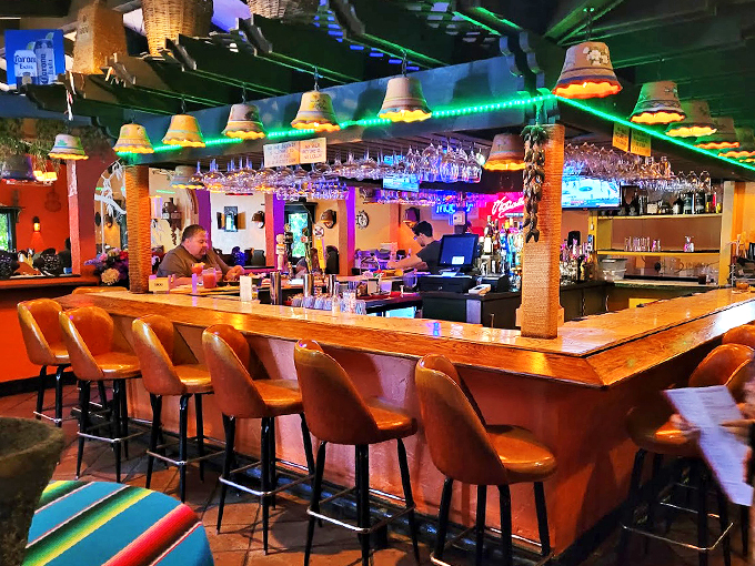The bar's wooden counter tells stories of countless margaritas and memories, while ceramic lamps cast a warm glow overhead.