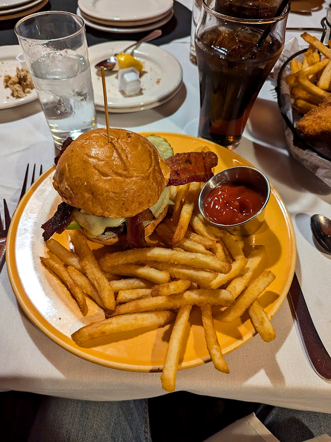 This isn't just a burger, it's comfort food architecture - stacked high with crispy bacon and golden fries.