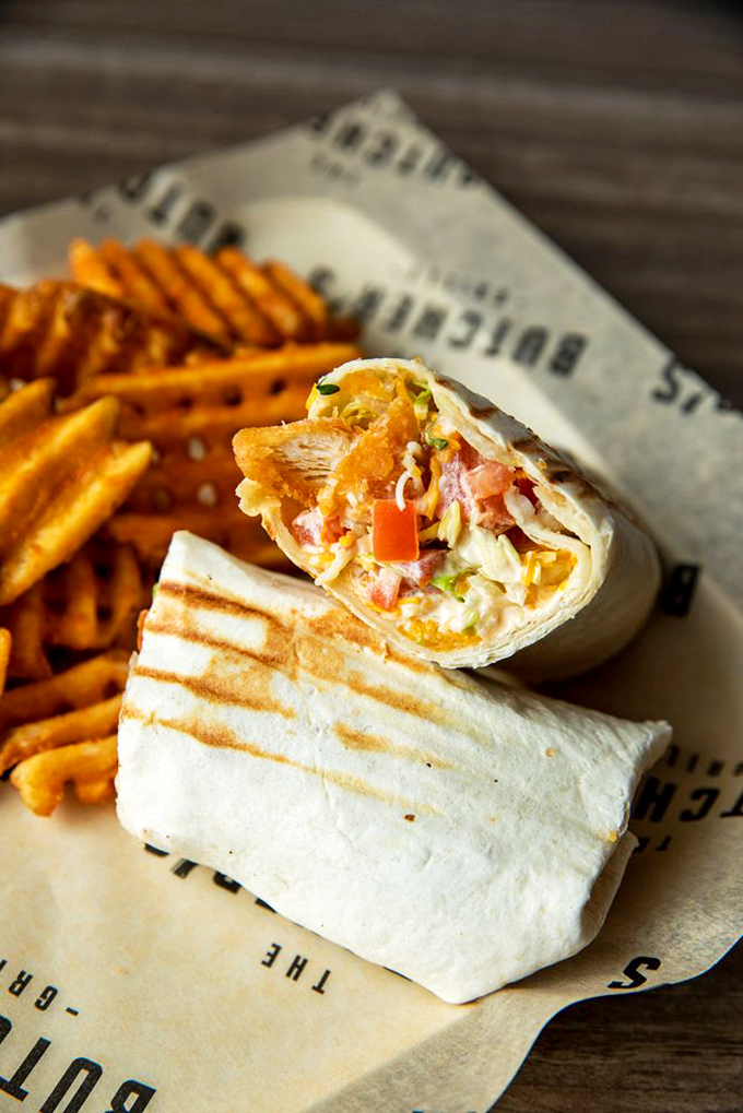 This isn't your average wrap - crispy chicken, fresh veggies, and creamy sauce create a handheld masterpiece. Photo credit: The Butcher's Grille