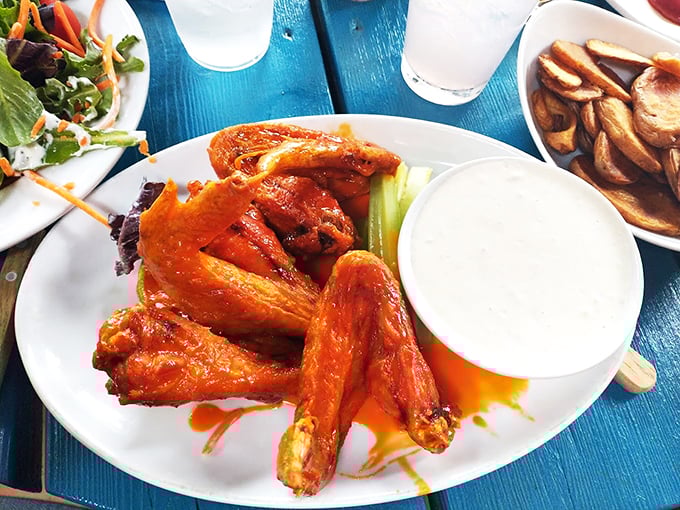 A plate of perfectly glazed wings sits ready for battle, accompanied by crisp celery and cooling ranch - the holy trinity of wing perfection.