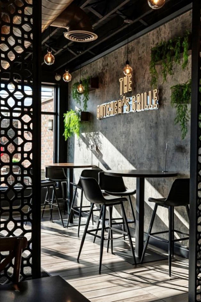 Geometric screens and hanging plants create an urban oasis where modern design meets Middle Eastern warmth.