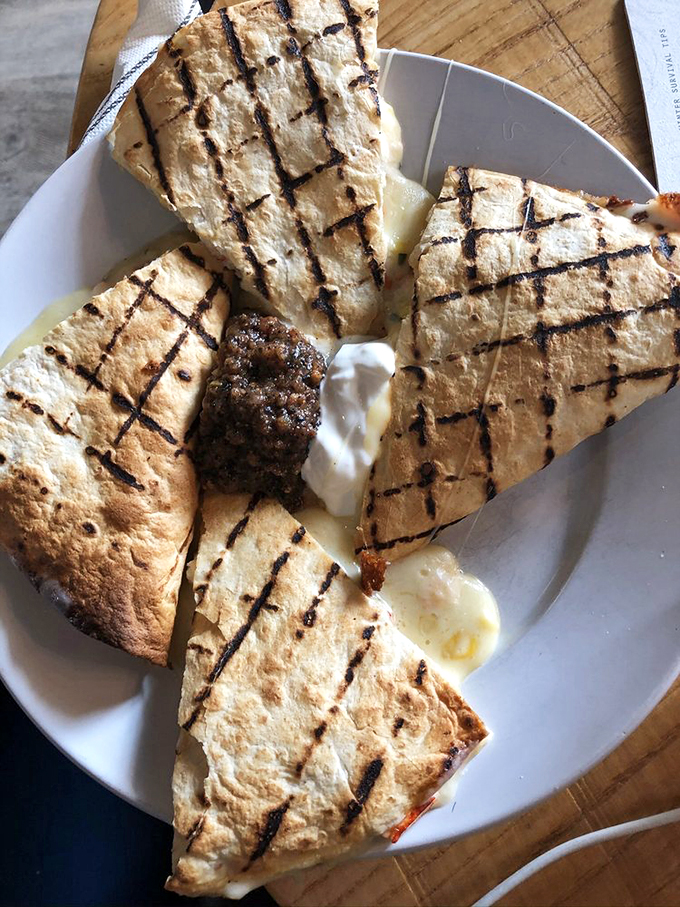 This grilled quesadilla isn't just dinner &ndash; it's edible art, with perfect grill marks and a generous dollop of cool cream. Photo credit: Claire L.