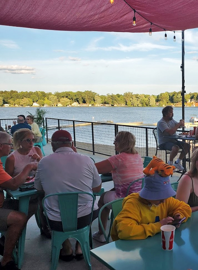 Where Michigan summer evenings are best spent: under a burgundy awning, watching boats drift by on Lake Odessa.