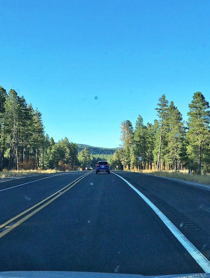Like a scene from a classic road movie, the highway stretches endlessly toward mountains painted in desert hues. 
