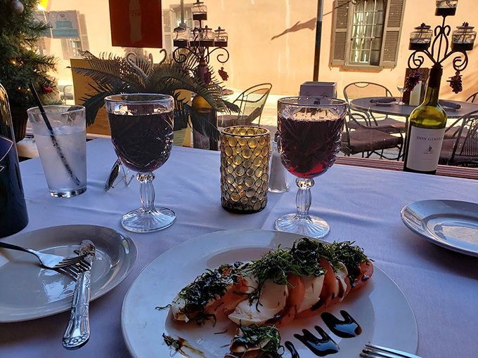 A table set for romance, or just a really good friendship with carbs. Either way, these generous pours of red wine promise a delightful evening ahead.