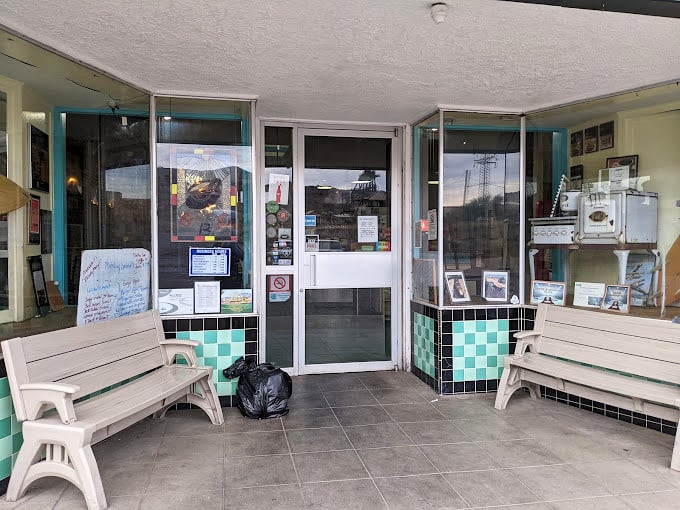 Classic benches flank the entrance, offering a perfect perch for morning people-watching or waiting for your weekend breakfast fix.