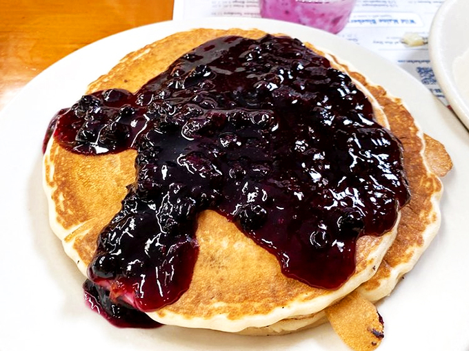 Pancake perfection: Where golden discs meet their berry best friend. It's like a warm hug for your taste buds.