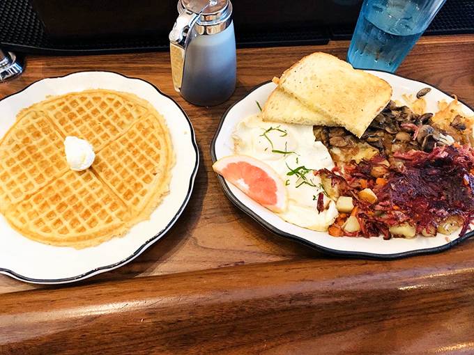 The holy trinity of breakfast: golden waffle, perfectly poached eggs, and that legendary hash. It's like the breakfast gods had a meeting.