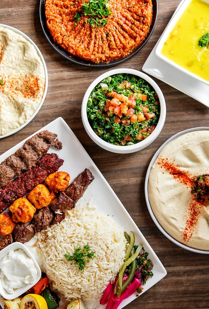A feast fit for royalty: grilled meats, fluffy rice, and fresh hummus share the spotlight like old friends at a reunion.