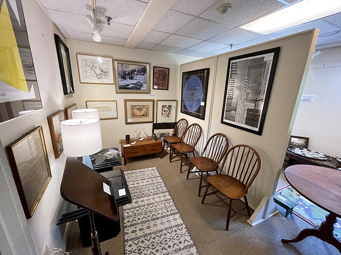 Windsor chairs line up like old friends beneath artwork spanning centuries, creating a cozy gallery atmosphere.