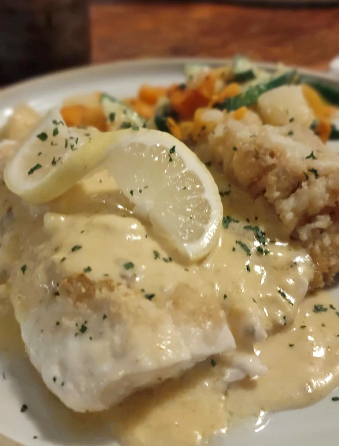 Tender haddock draped in lemon butter sauce, proving sometimes the simplest preparations create the most memorable meals.