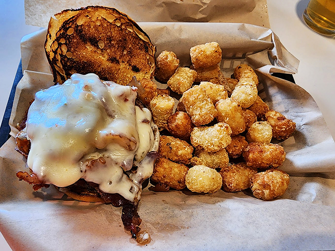 Golden-brown tater tots stand guard beside a burger that's dressed to impress. It's comfort food wearing its Sunday best.