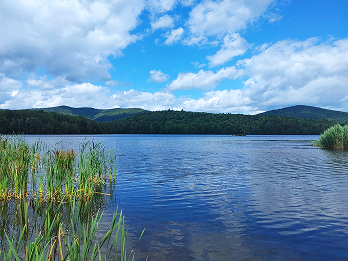 Tranquil waters mirror cloud-studded skies, creating a scene so serene it could lower your blood pressure just by looking at it.
