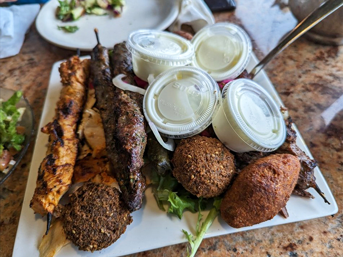 A feast fit for royalty: grilled meats, falafel, and fresh vegetables share space with generous portions of garlic sauce.