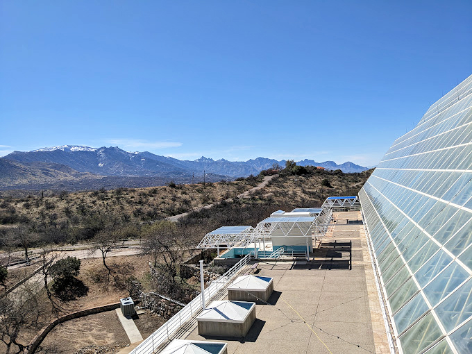 The desert sun plays across acres of glass panels, while the Santa Catalina Mountains stand guard in the distance. 