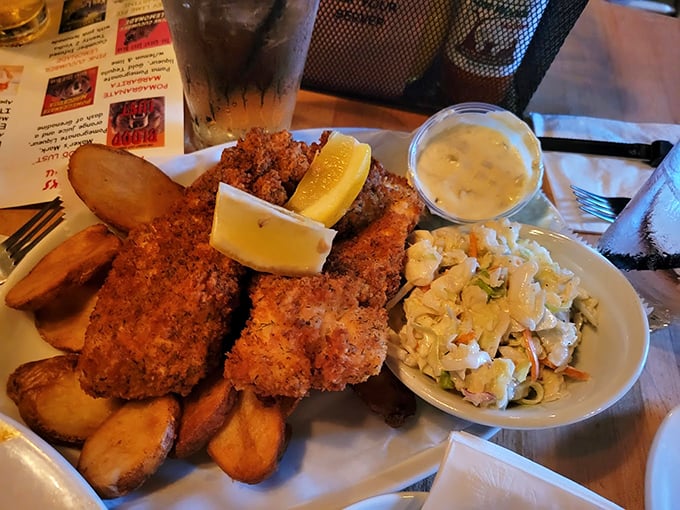 Golden-brown fish fillets with a crispy coating that shatters like glass, served with a side of creamy coleslaw and fresh lemon.
