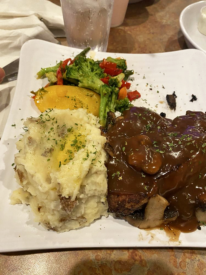 Meatloaf with mash and veggies] Comfort food perfection: tender meatloaf draped in savory gravy alongside buttery mashed potatoes and garden-fresh vegetables.