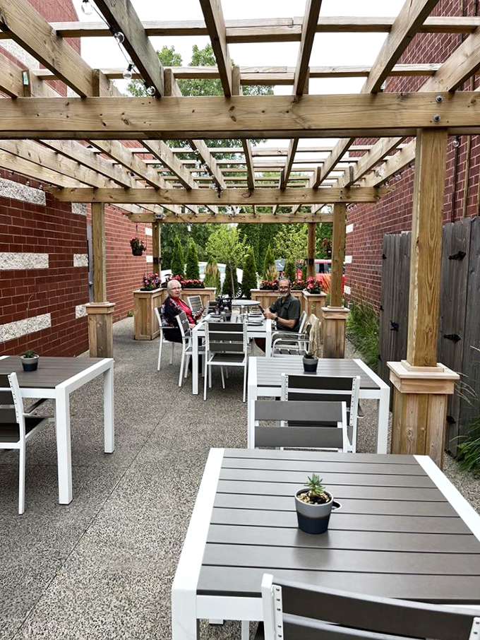 This charming pergola-covered patio feels like discovering a secret garden, complete with modern furnishings and lush greenery.