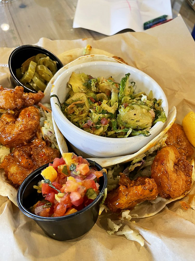 Golden-fried shrimp nestled in fresh tortillas, accompanied by vibrant slaw and tropical salsa&mdash;a taste of coastal paradise.
