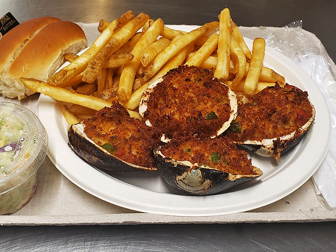 Stuffed clams wearing their golden-brown crumb topping like a badge of honor, accompanied by crispy fries and fresh coleslaw.