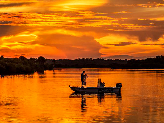 Nature's grand finale: a Tomoka sunset! The sky ignites in a blaze of orange and pink, reflected in waters as smooth as glass.
