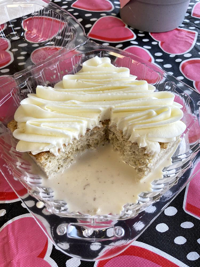 A cloud of white frosting floats atop this perfectly soaked tres leches cake, creating a heavenly pool of sweetness.