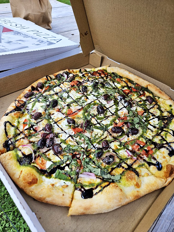 Mediterranean meets Vermont in this colorful creation, where olives and fresh herbs dance across a perfectly charred crust.