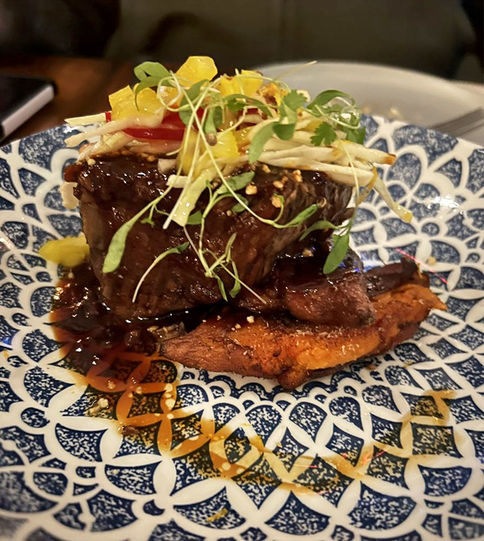 Tender brisket rests on a plate worthy of a museum, proving that sometimes the prettiest things taste even better.