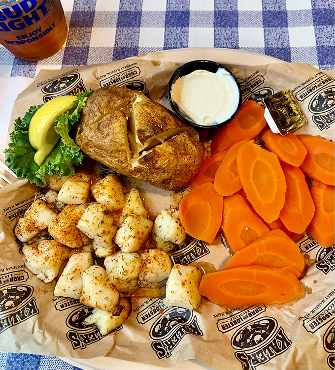 Perfectly seasoned scallops share the plate with colorful carrots and a baked potato - a seaside symphony of flavors.