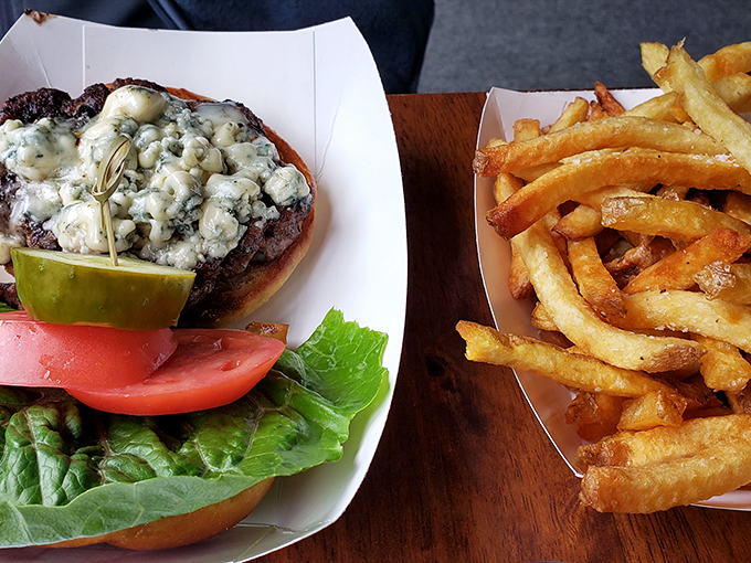 A blue cheese-crowned burger that's not just a meal, it's a revelation, accompanied by perfectly crispy hand-cut fries. Photo credit: Brooks