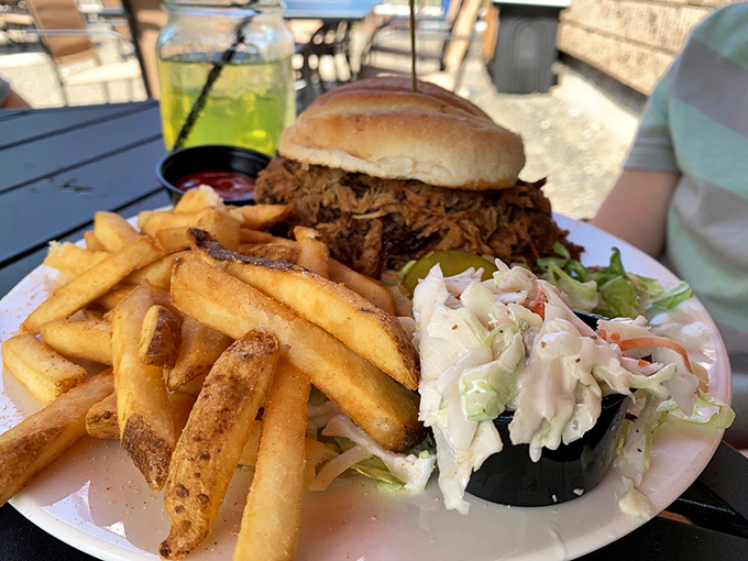 A hearty pulled pork sandwich that proves this barn knows its BBQ, accompanied by crispy fries and fresh coleslaw.